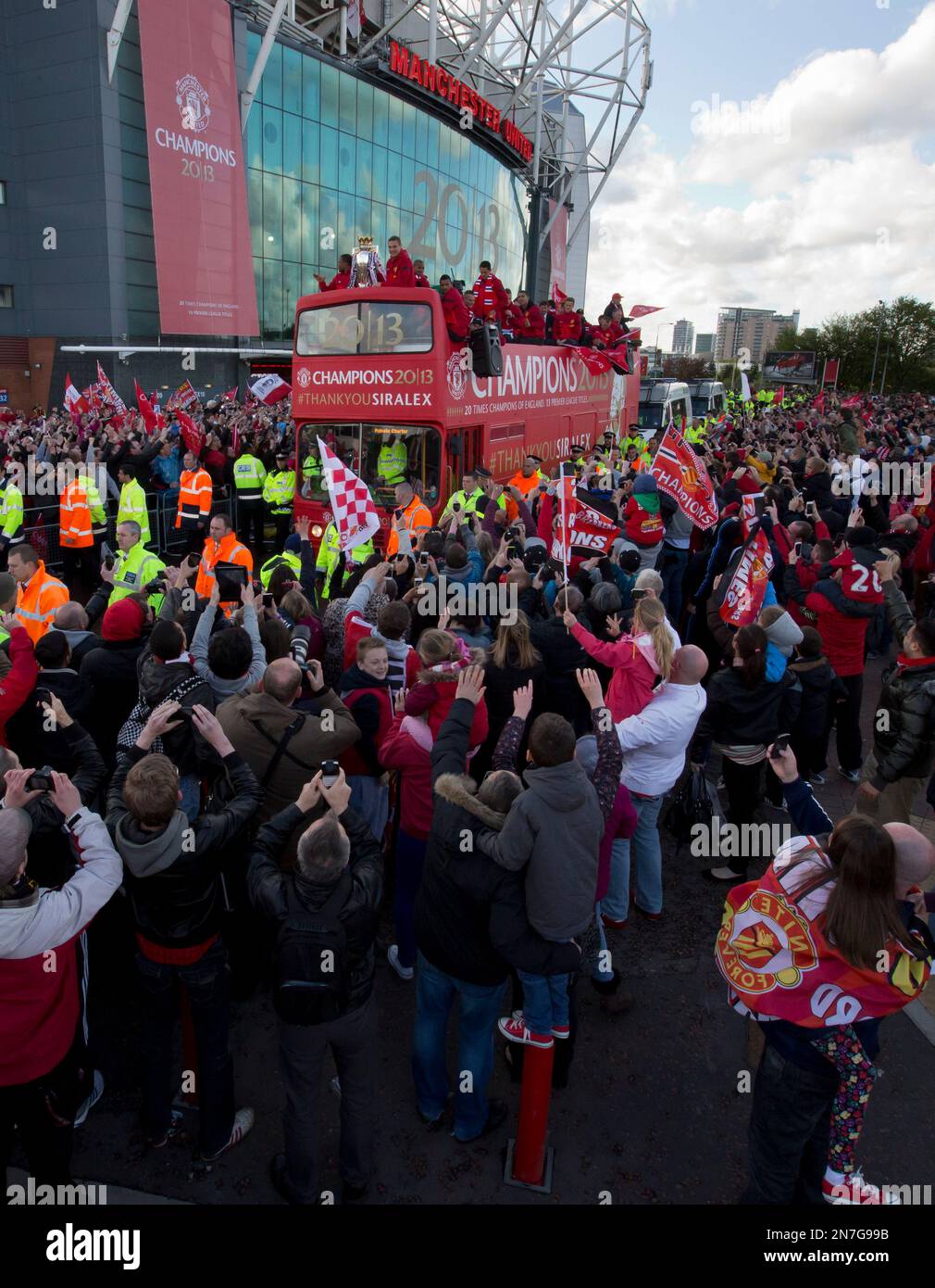 Manchester United players on an open top bus are driven past Old ...
