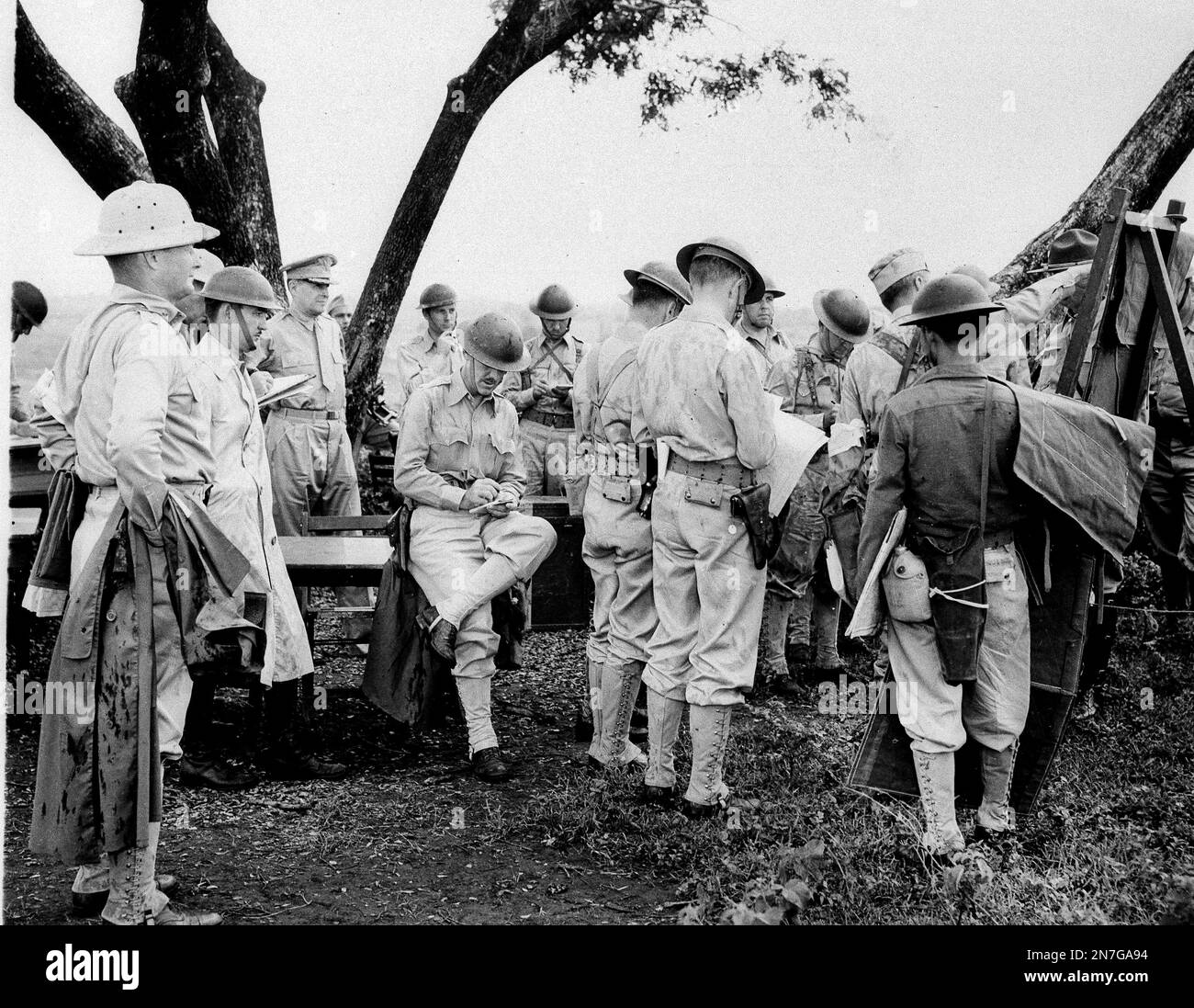 Gen. Douglas MacArthur (wearing cap, standing against tree at left rear ...
