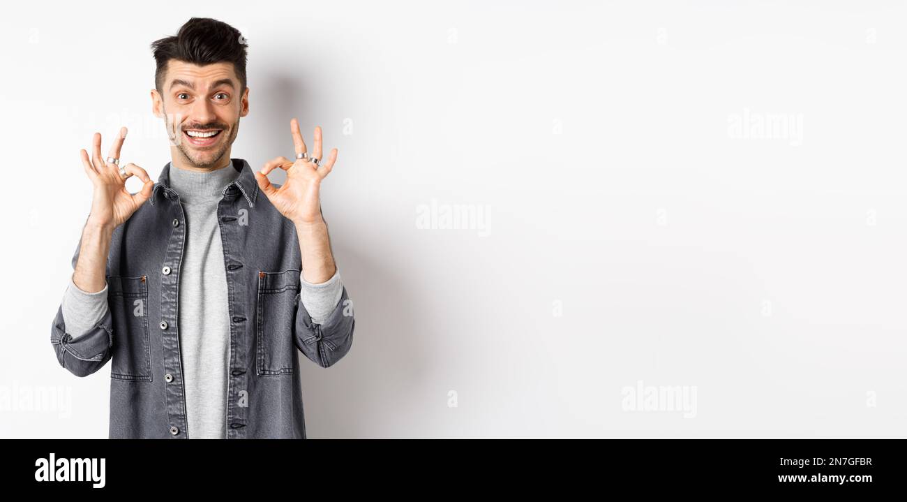 Happy guy say yes, smiling and showing okay signs, like good product ...
