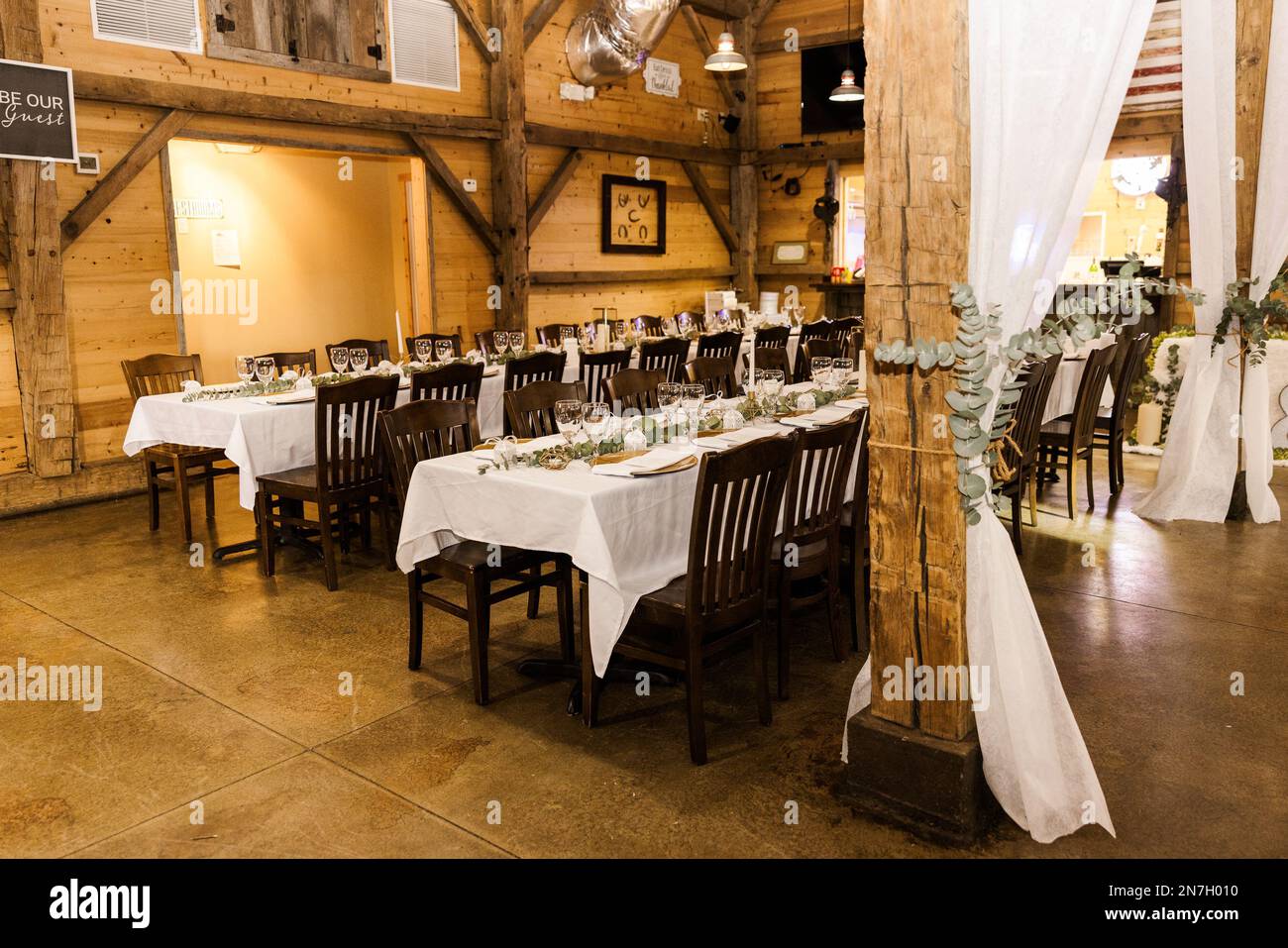A wooden hall in vintage style with beautifully set tables decorated ...