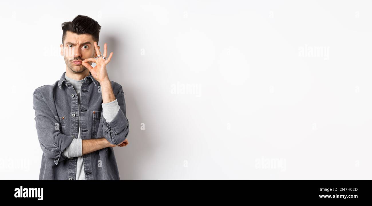 Serious man making zip gesture, tell to keep mouth shut, frowning and ...