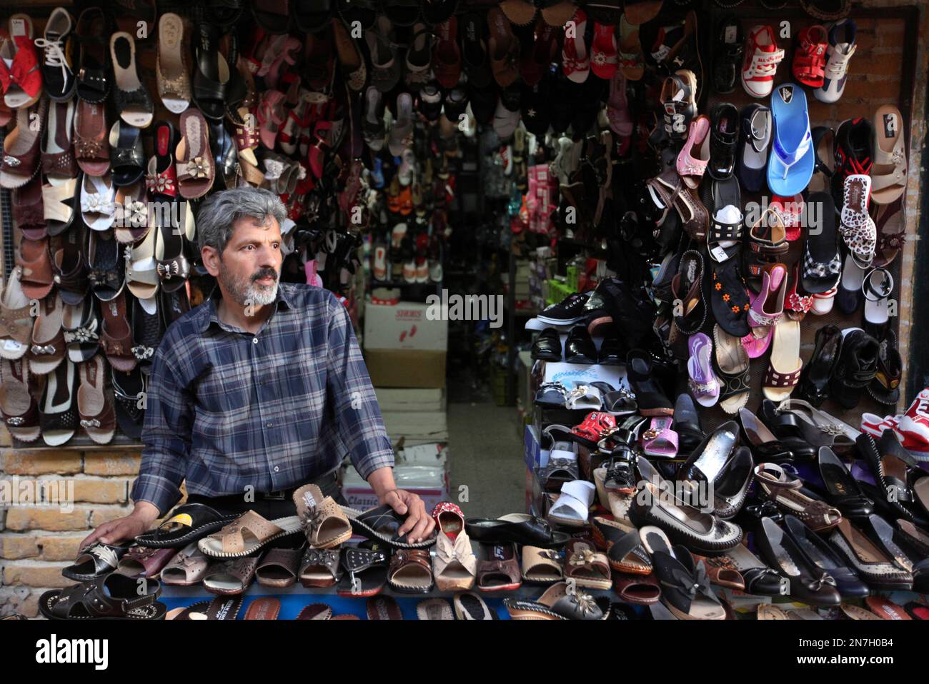 In this picture taken on Sunday, May 4, 2013, an Iranian shoe seller ...