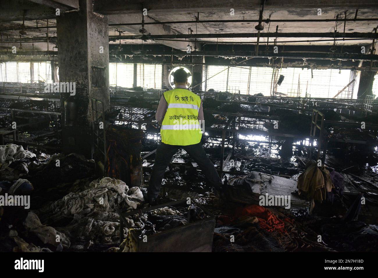 An investigator surveys the scene of a fire at a garment factory in ...