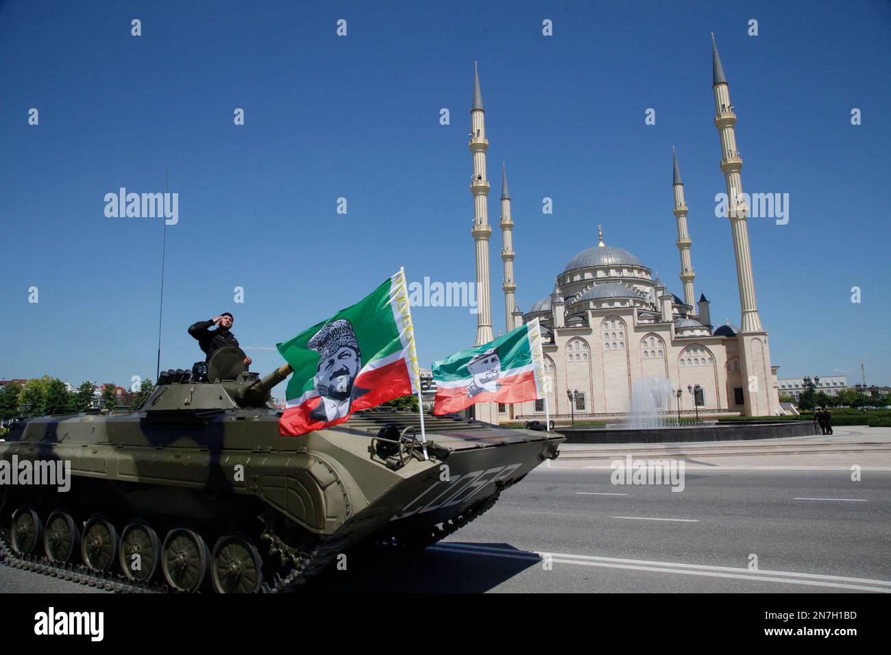 Chechen Interior Ministry soldier on top an APC with Chechen flags ...