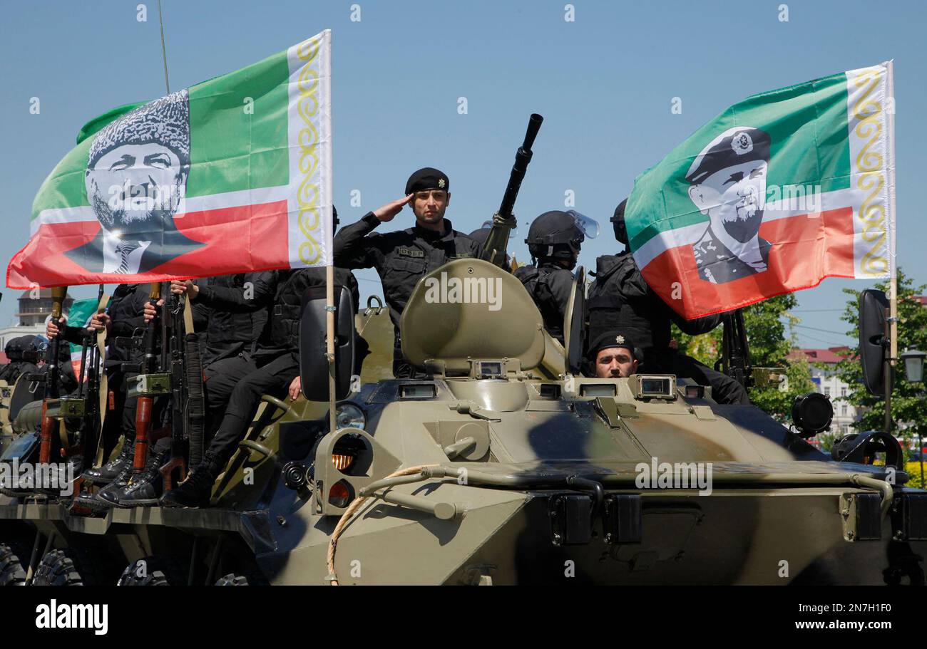 Chechen Interior Ministry soldiers on top an APC with Chechen flags ...