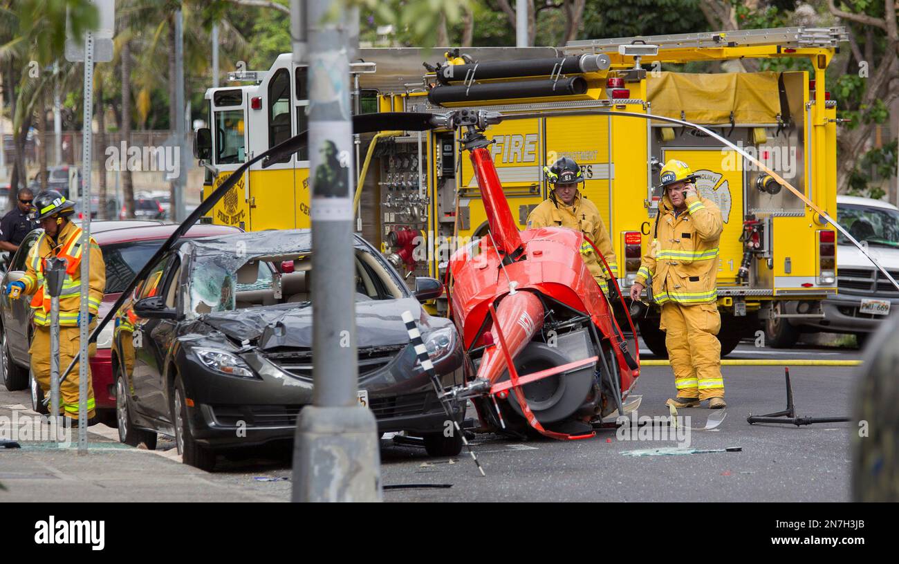 Honolulu firefighters look over the wreckage of a small helicopter that ...
