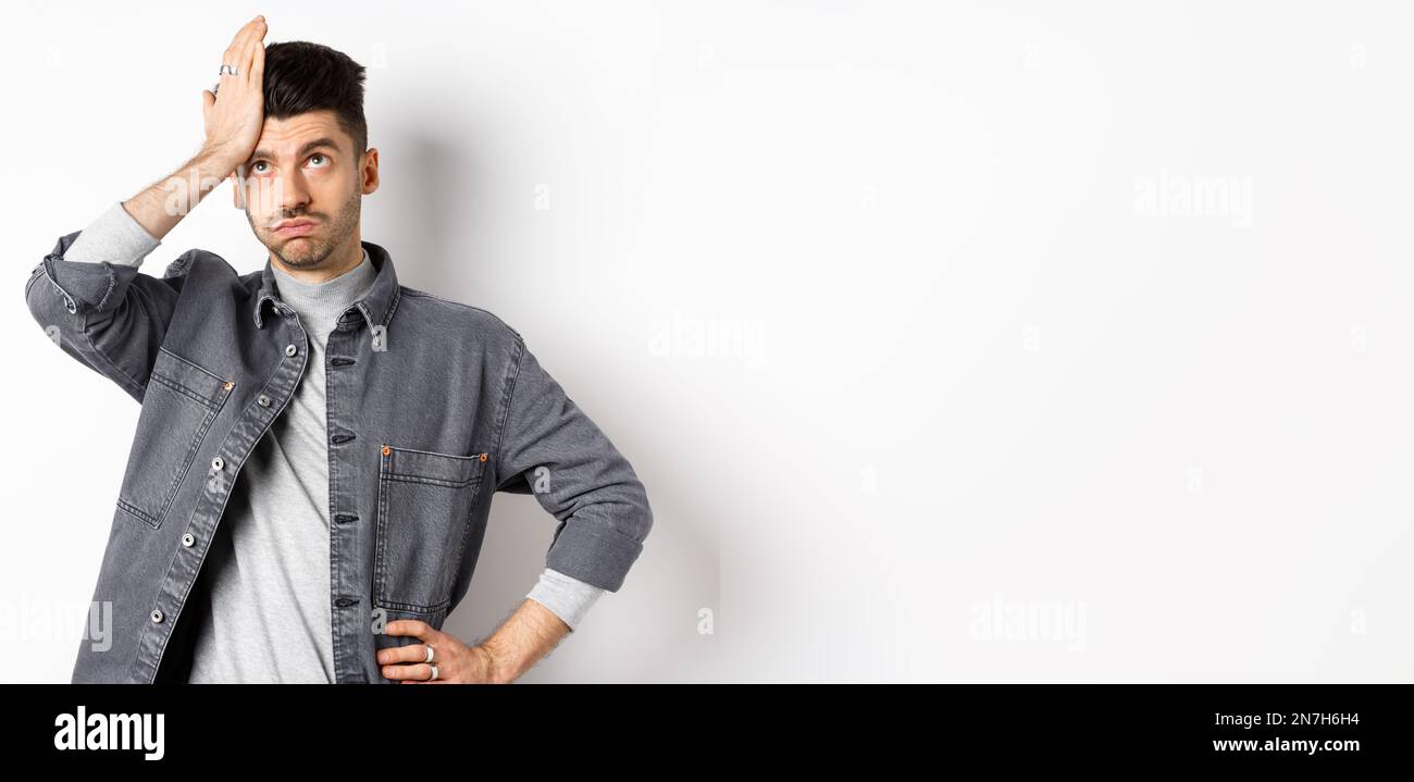 Annoyed young man looking tired or bothered, roll eyes and slap ...