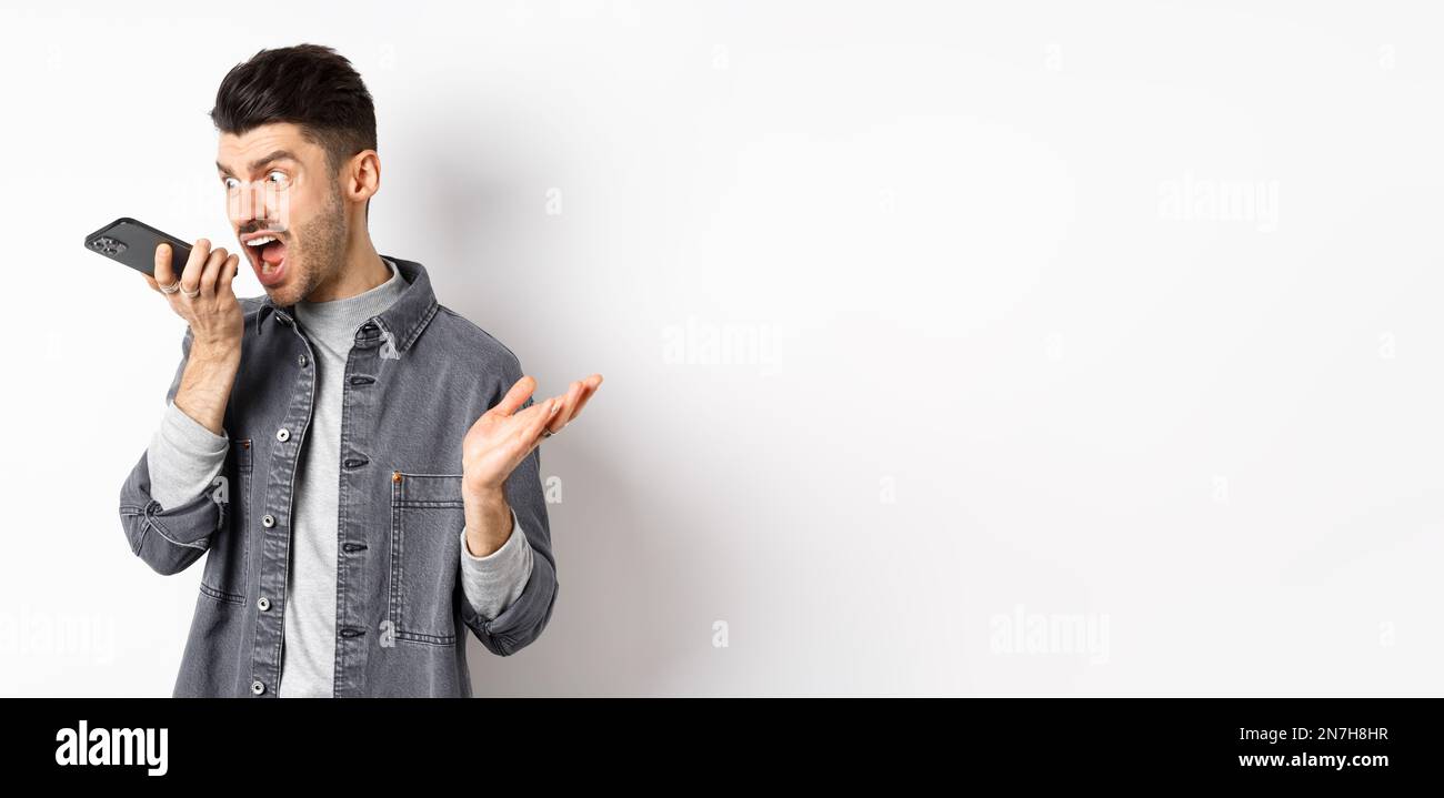 Angry guy shouting at speakerphone, scream on mobile phone, leaving ...