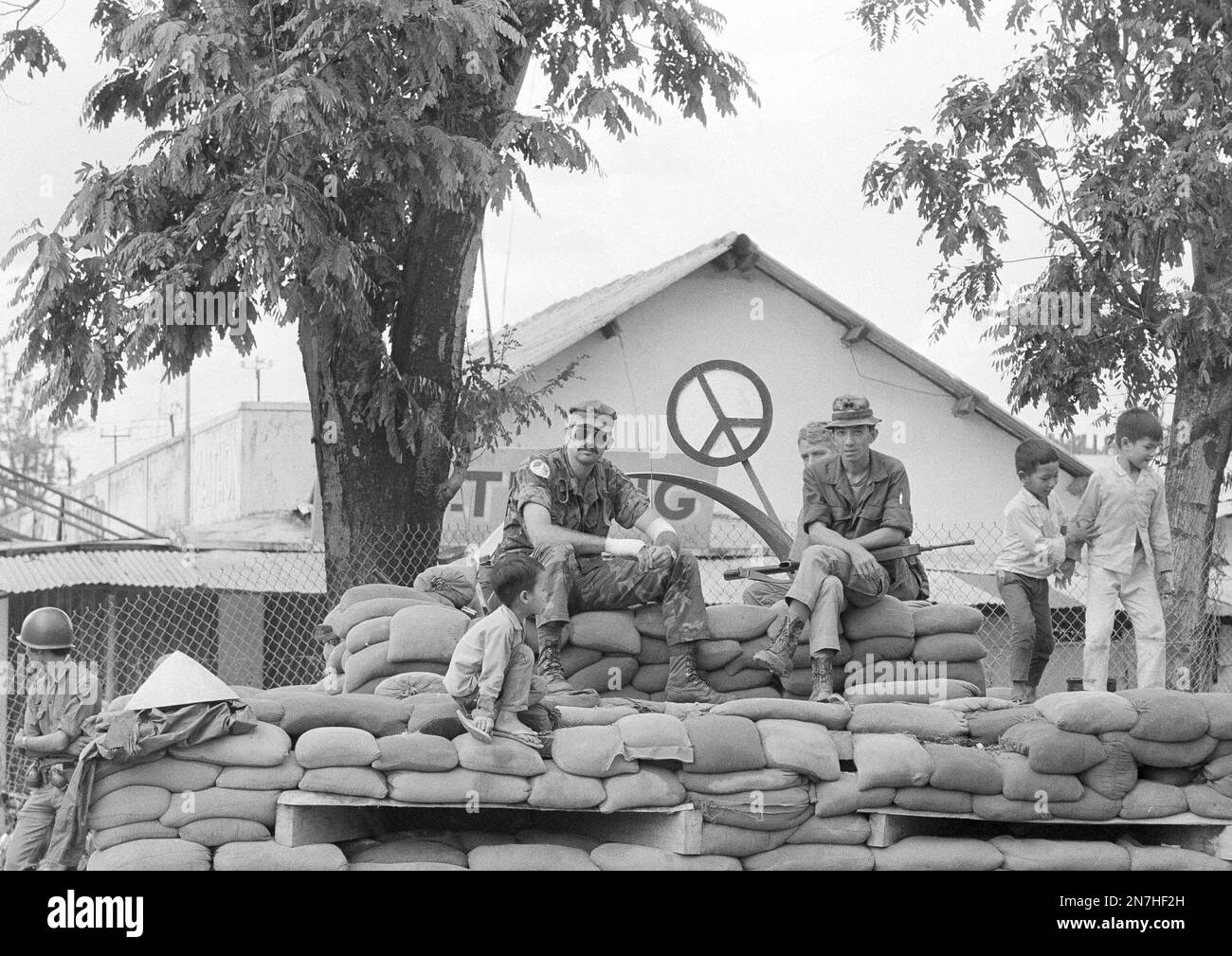 An American advisor and a Vietnamese officer stand guard at an advisory ...