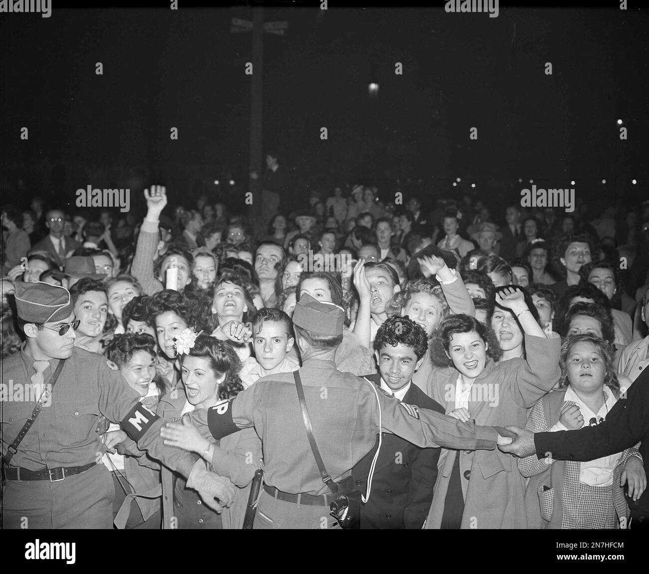 Military police try to hold back a shouting group of people who swirled ...