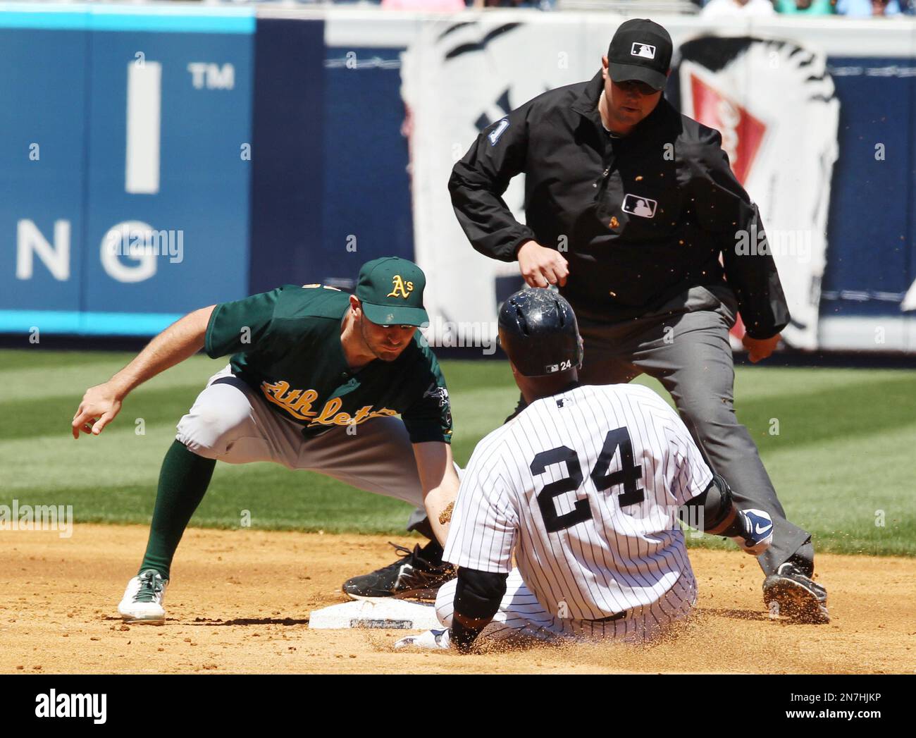 New York Yankees' Robinson Cano (24) is tagged out by Oakland Athletics ...