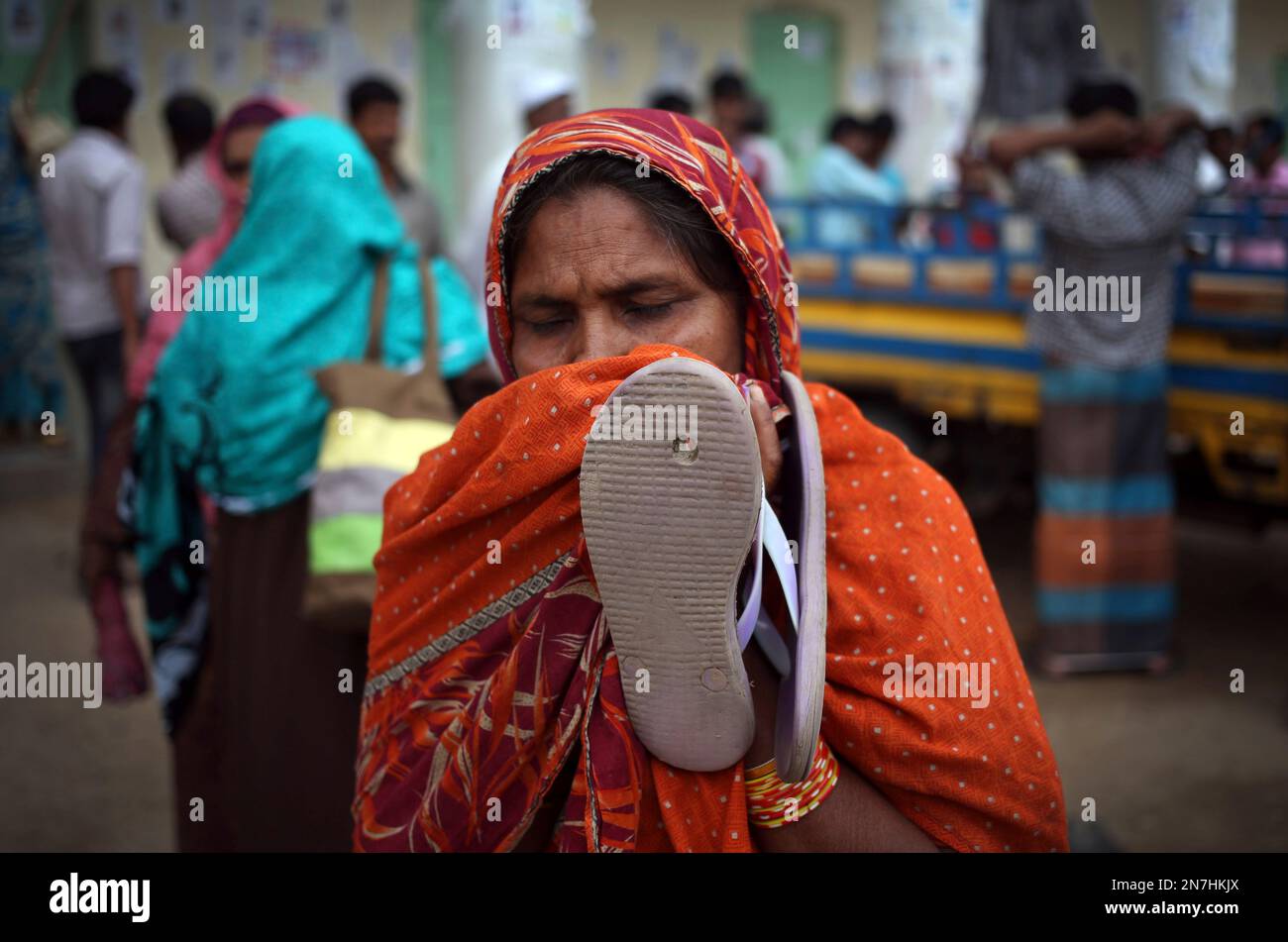 A woman covers her nose to block out the smell of bodies as she leaves ...