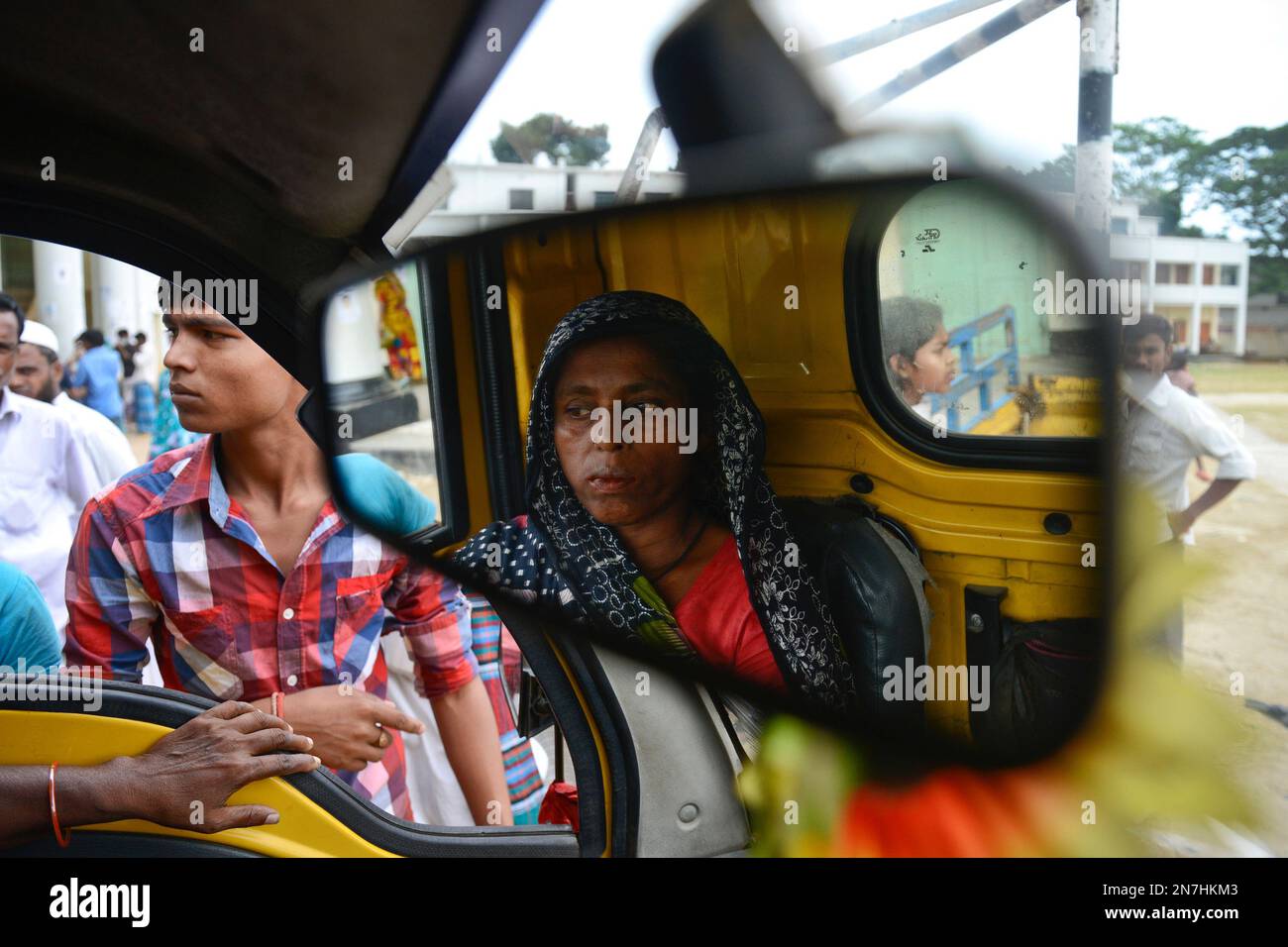 A women sits in a truck while transporting her brother's body home ...