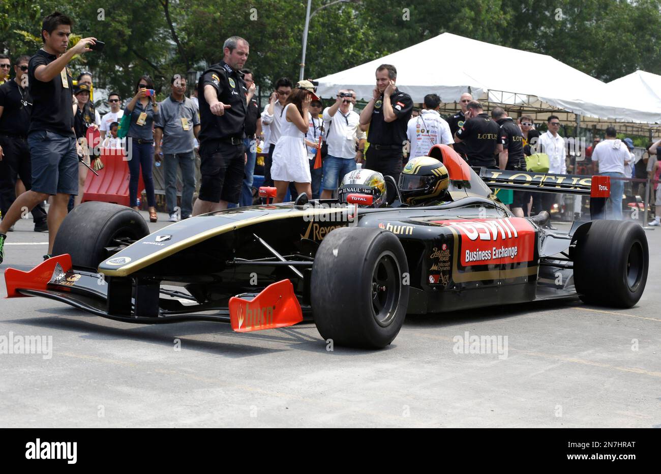 Manila Mayor Alfredo Lim rides at the back with a Lotus Formula One ...