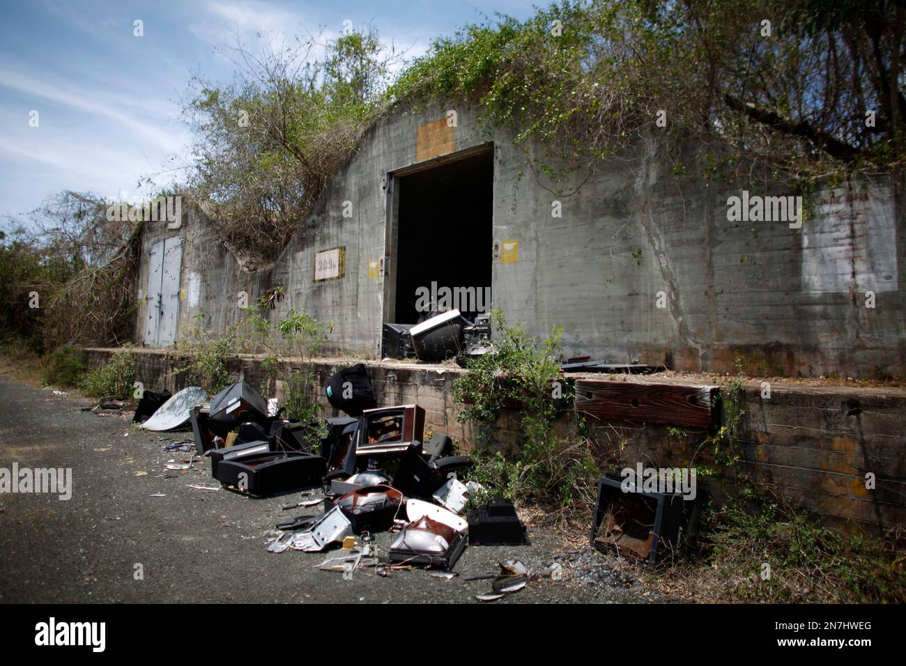 Discarded electronic devices lie scattered in front of an abandoned ...
