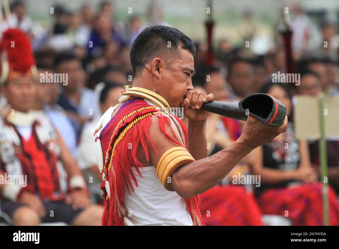 A Naga tribal man blows a horn, an indigenous musical instrument ...