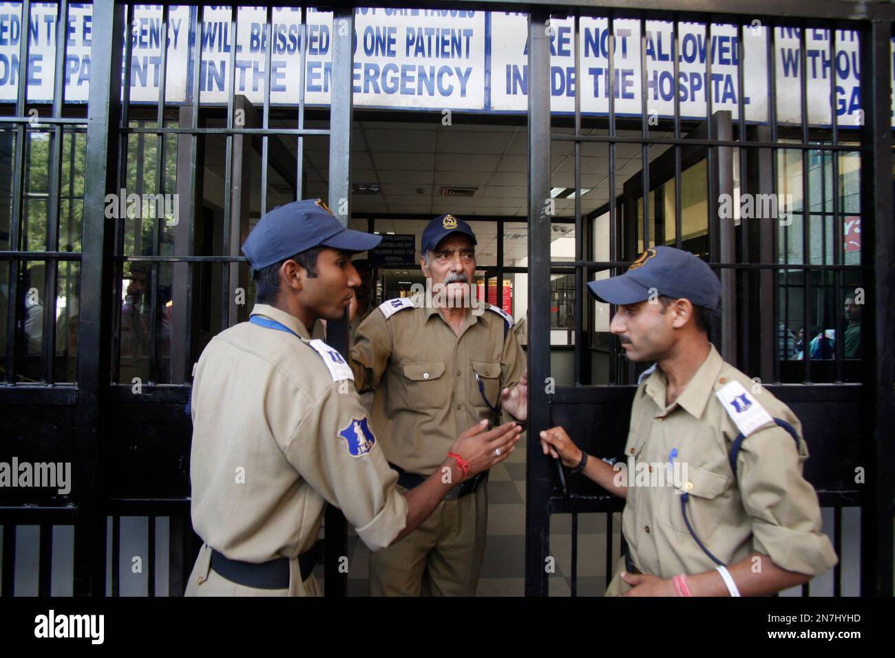 Security guards stand at the gate of a hospital where a Pakistani ...