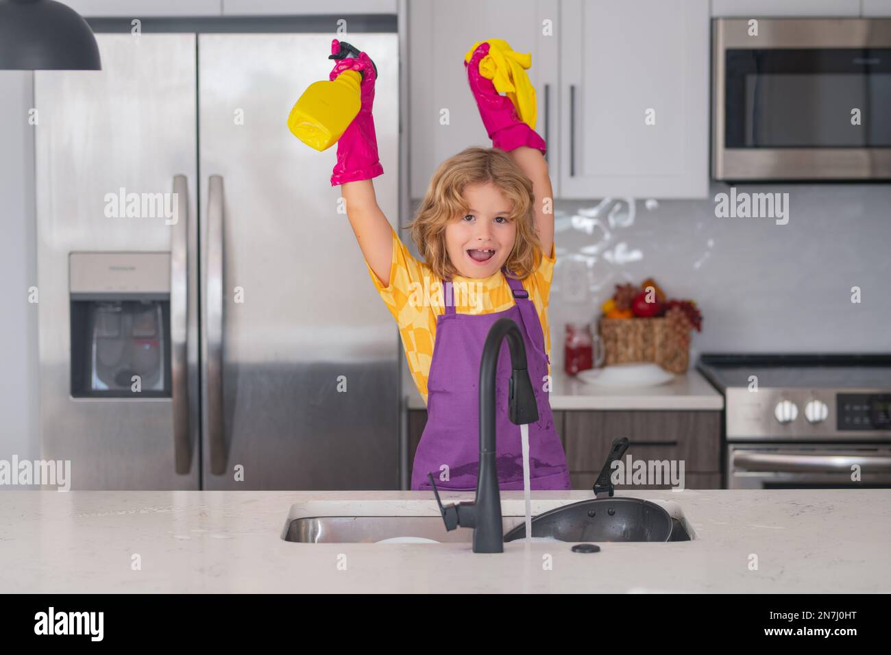 Washing and cleaning concept. Portrait of child cleaning in the kithen ...