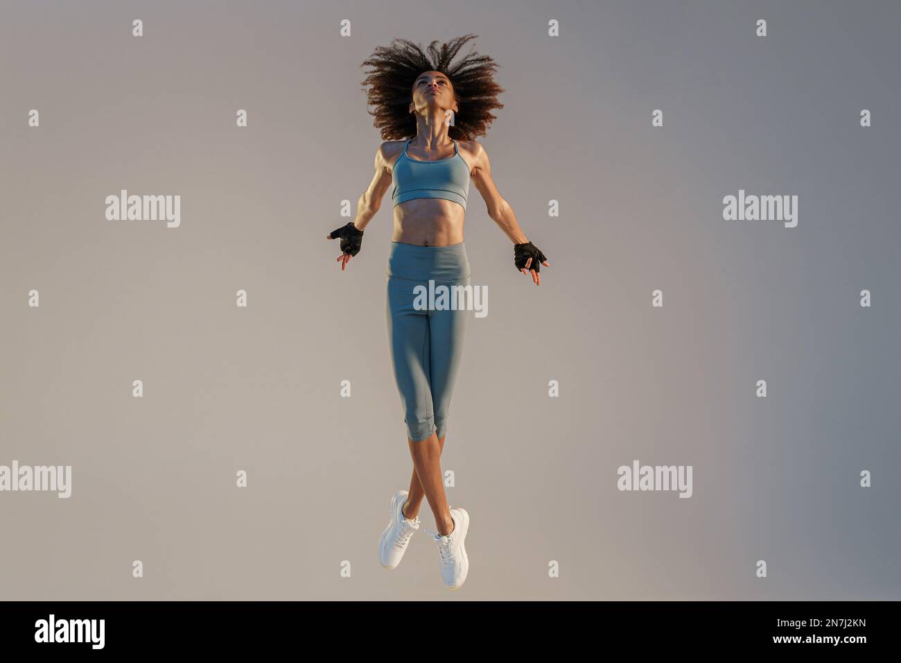 Active sporty woman in sportswear jumping on studio background. Sport ...
