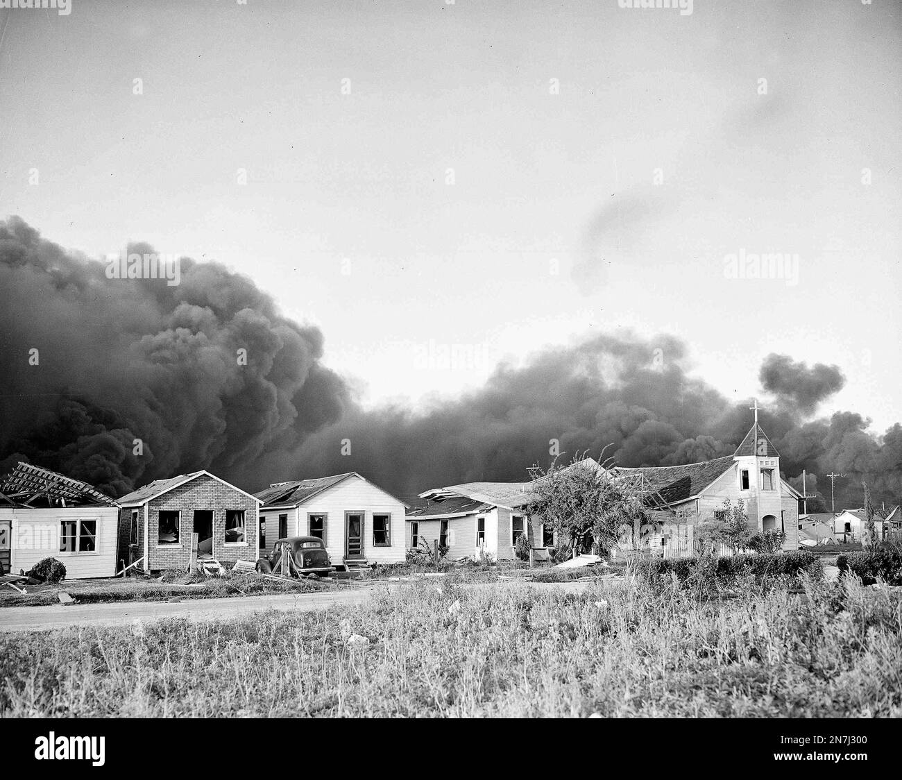 A line of damaged homes along a street in the residential section of ...
