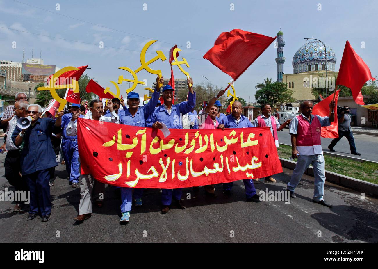 Supporters of the Iraqi Communist Party wave hold symbolic sickles ...