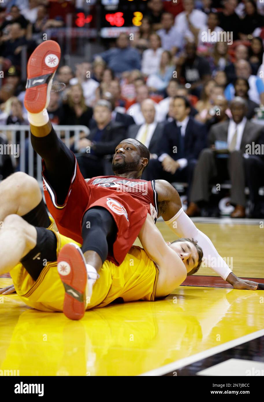 Miami Heat guard Dwyane Wade, top, falls on Cleveland Cavaliers center ...
