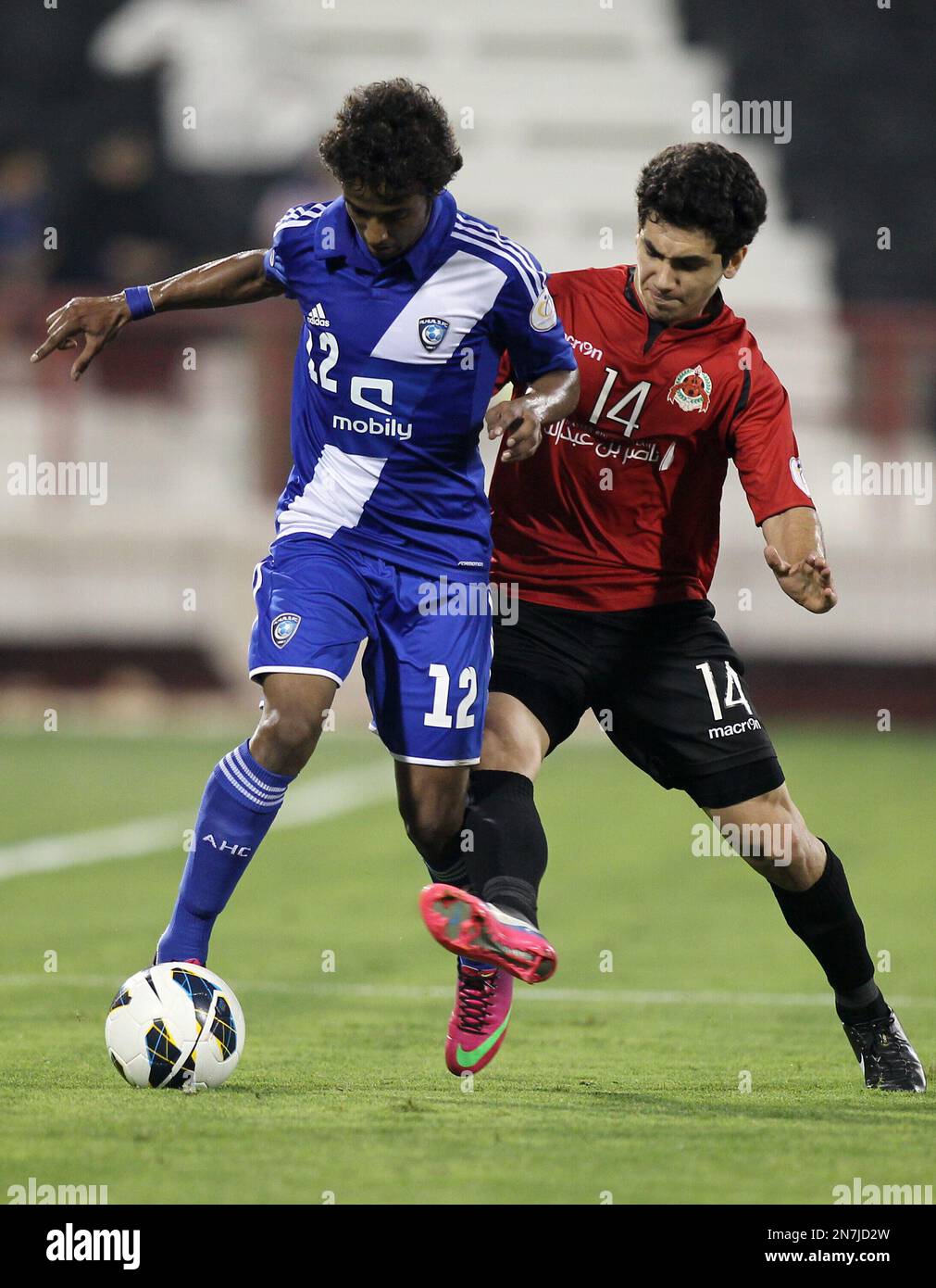 Qatar's Al-Rayyan club Mohamed Alaaeldin, right, fights for the ball ...