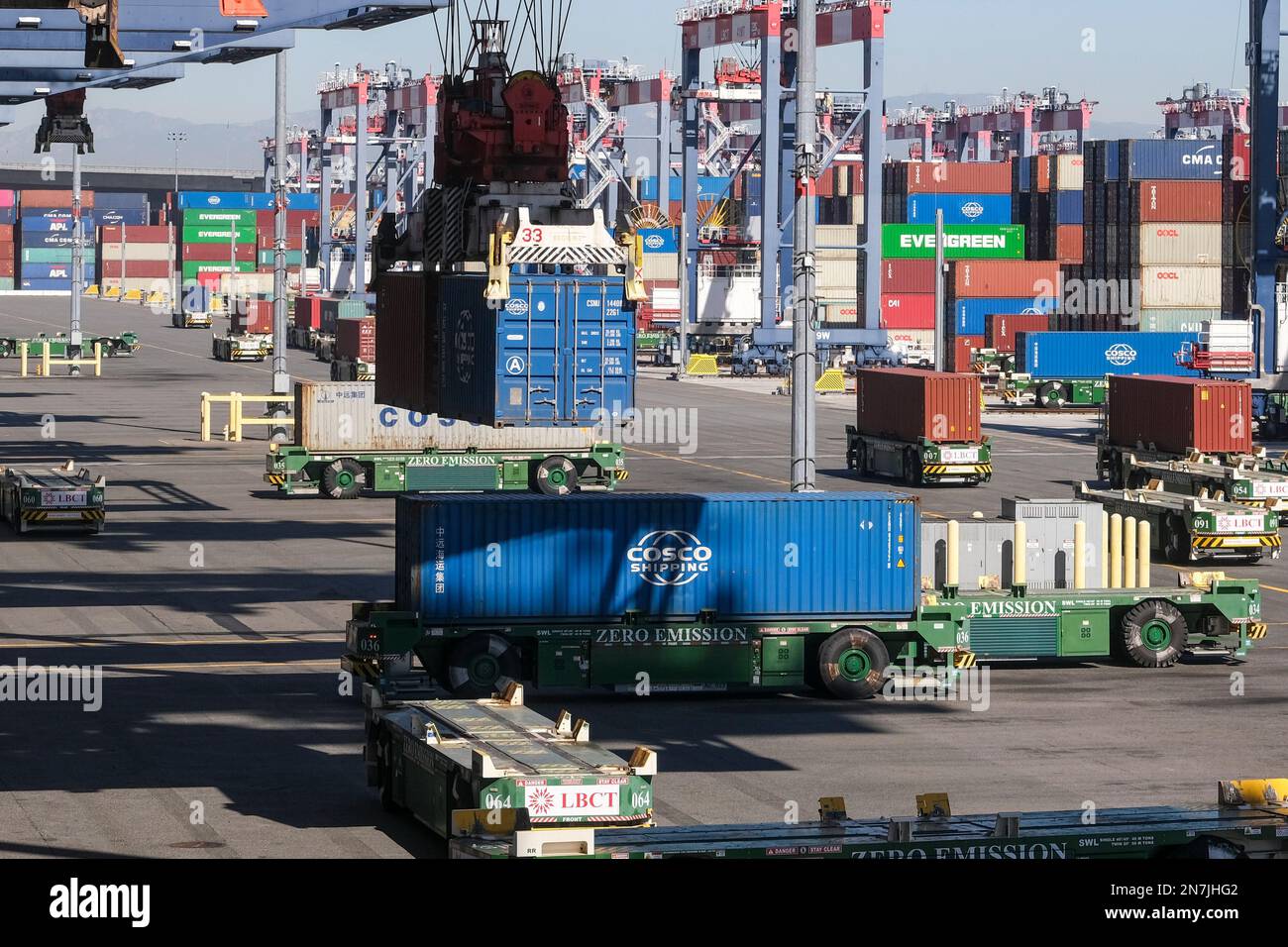 Computer-controlled cargo cranes rapidly lift containers from ships to ...