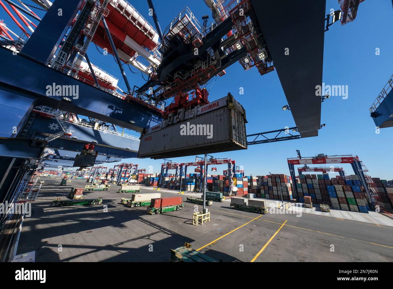 Computer-controlled cargo cranes rapidly lift containers from ships to ...
