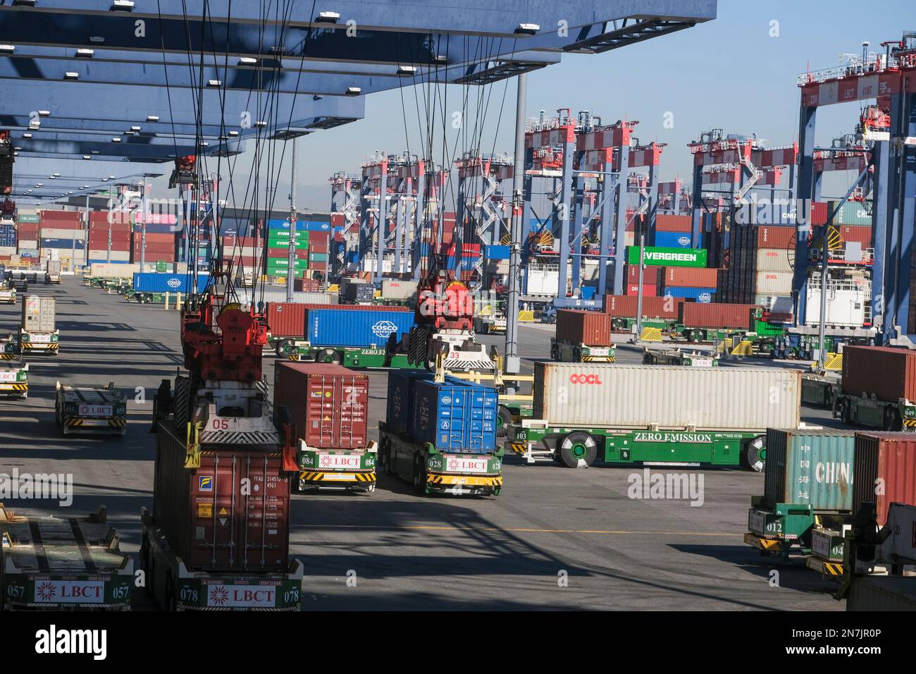 Computer-controlled cargo cranes rapidly lift containers from ships to ...