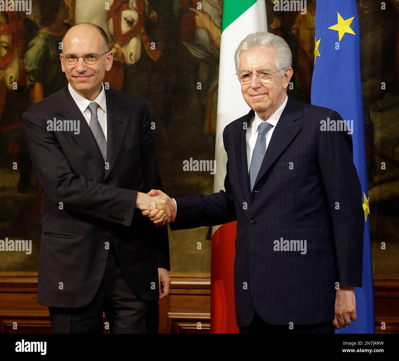 Premier Enrico Letta, left, and outgoing Premier Mario Monti shake ...