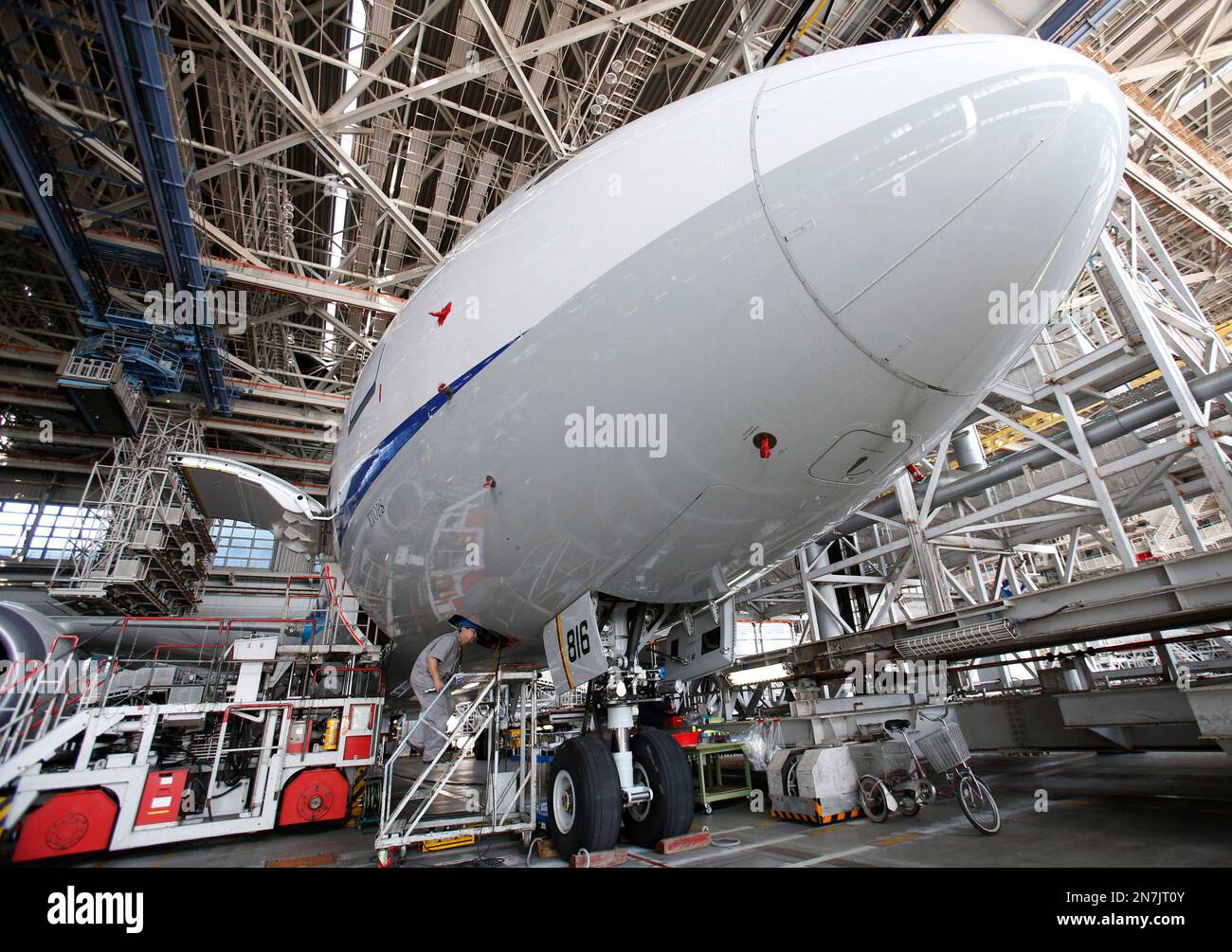 A member of Boeing Aircraft-on-Ground team works on the fuselage of an ...