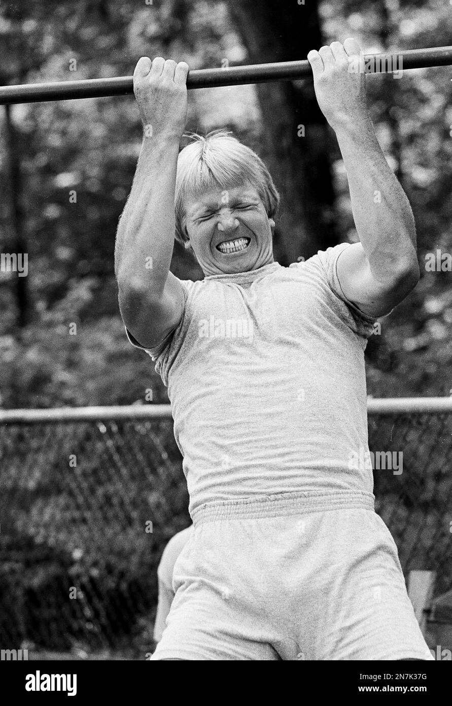 New York Giants quarterback Phil Simms limbers up on the chinning bar ...