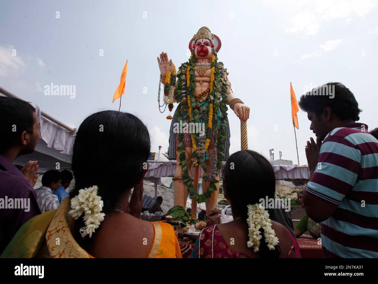 Indian Hindu devotees offer prayers before an idol of Hindu monkey-god ...