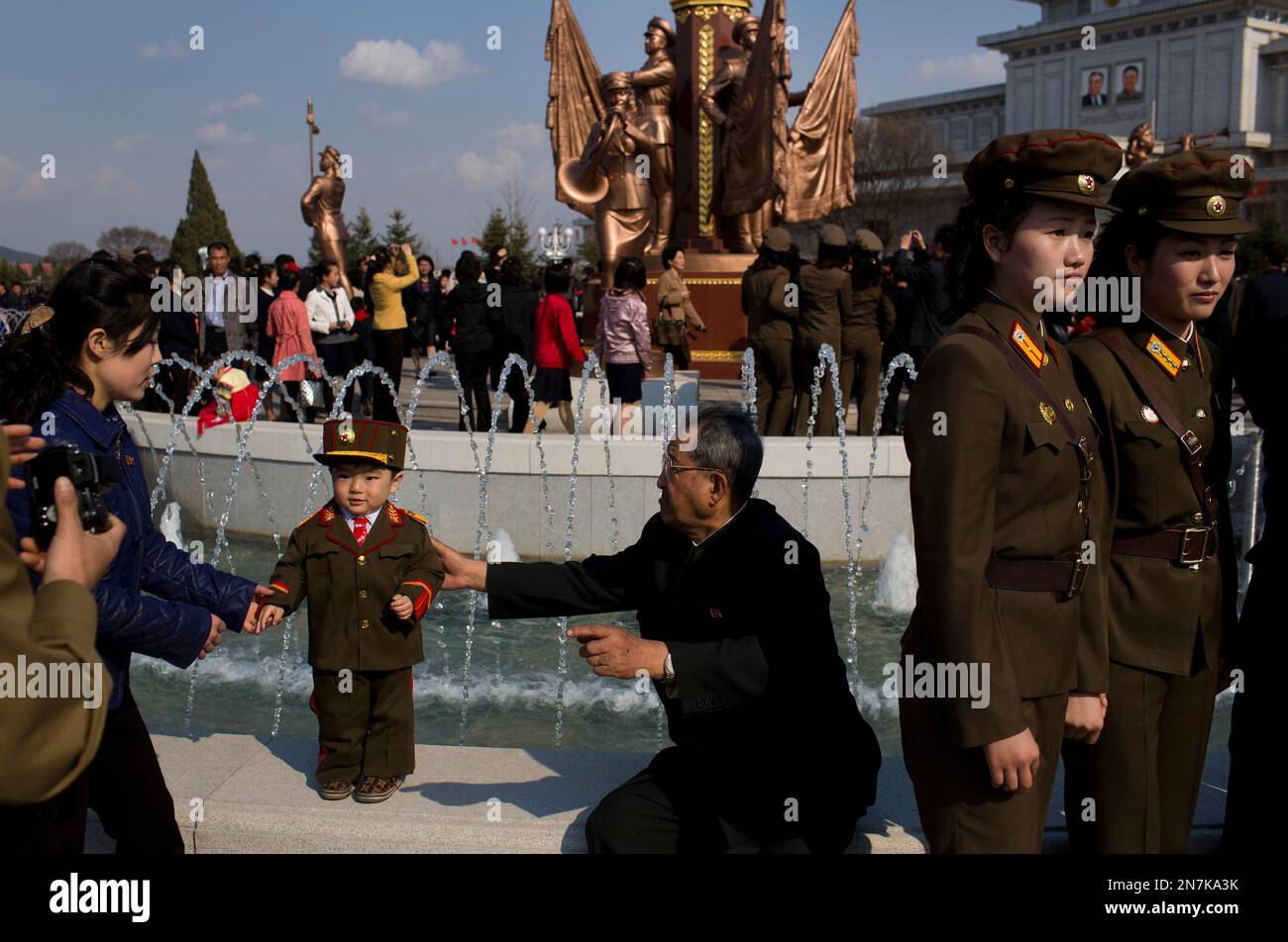 North Korean soldiers and civilians pose for souvenir photos in front ...