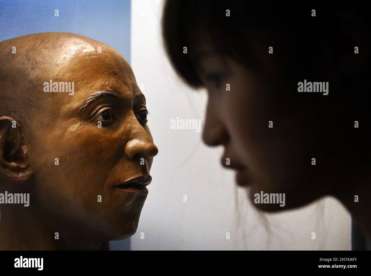 A young woman examines a reconstructed head of the Mummy of Nesperennub ...