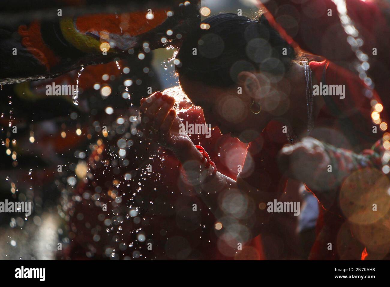 A Nepalese Hindu devotee sprinkles water at the Balaju Baise Dhara, or the 22 stone spouts ...