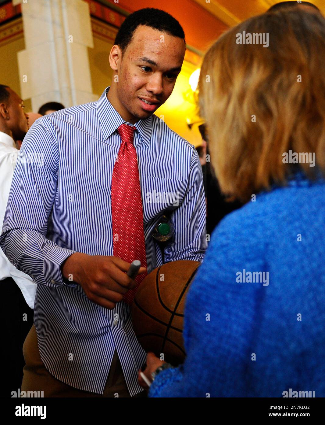 Connecticut's Shabazz Napier autographs a basketball for a fan during ...