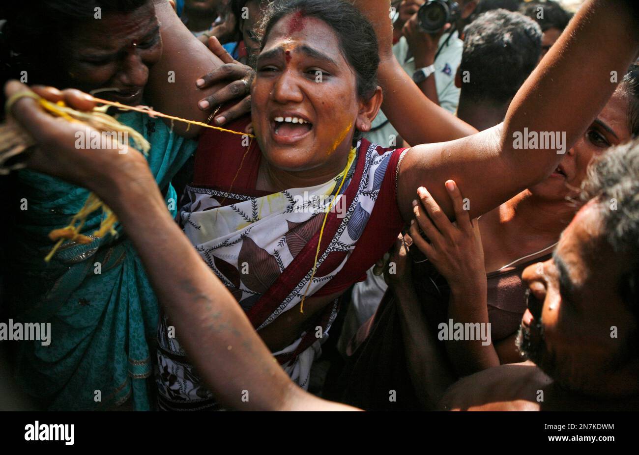 An Indian eunuch cries as a temple priest cuts off the holy string ...