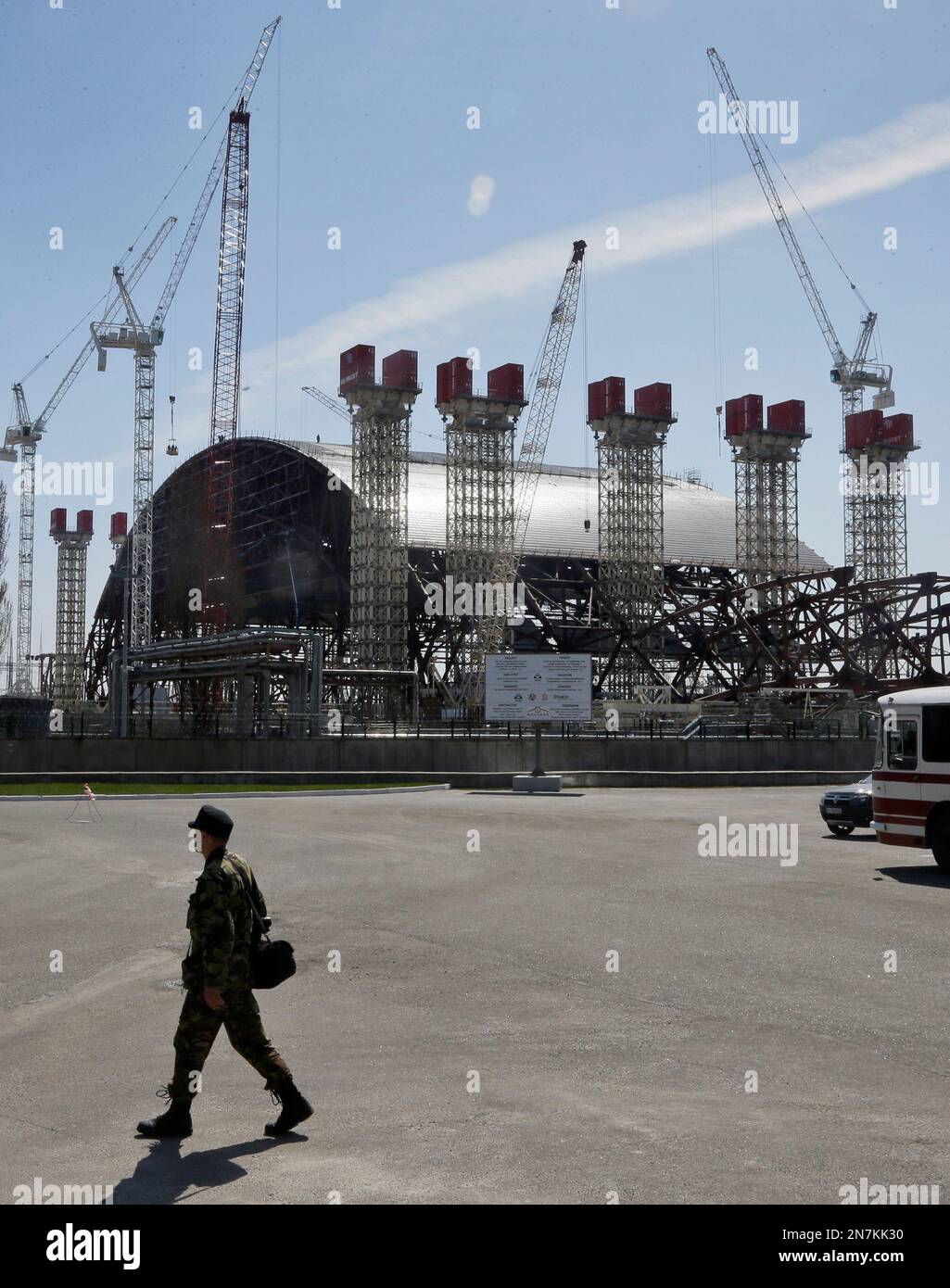 A worker passes by a gigantic steel-arch under construction to cover ...