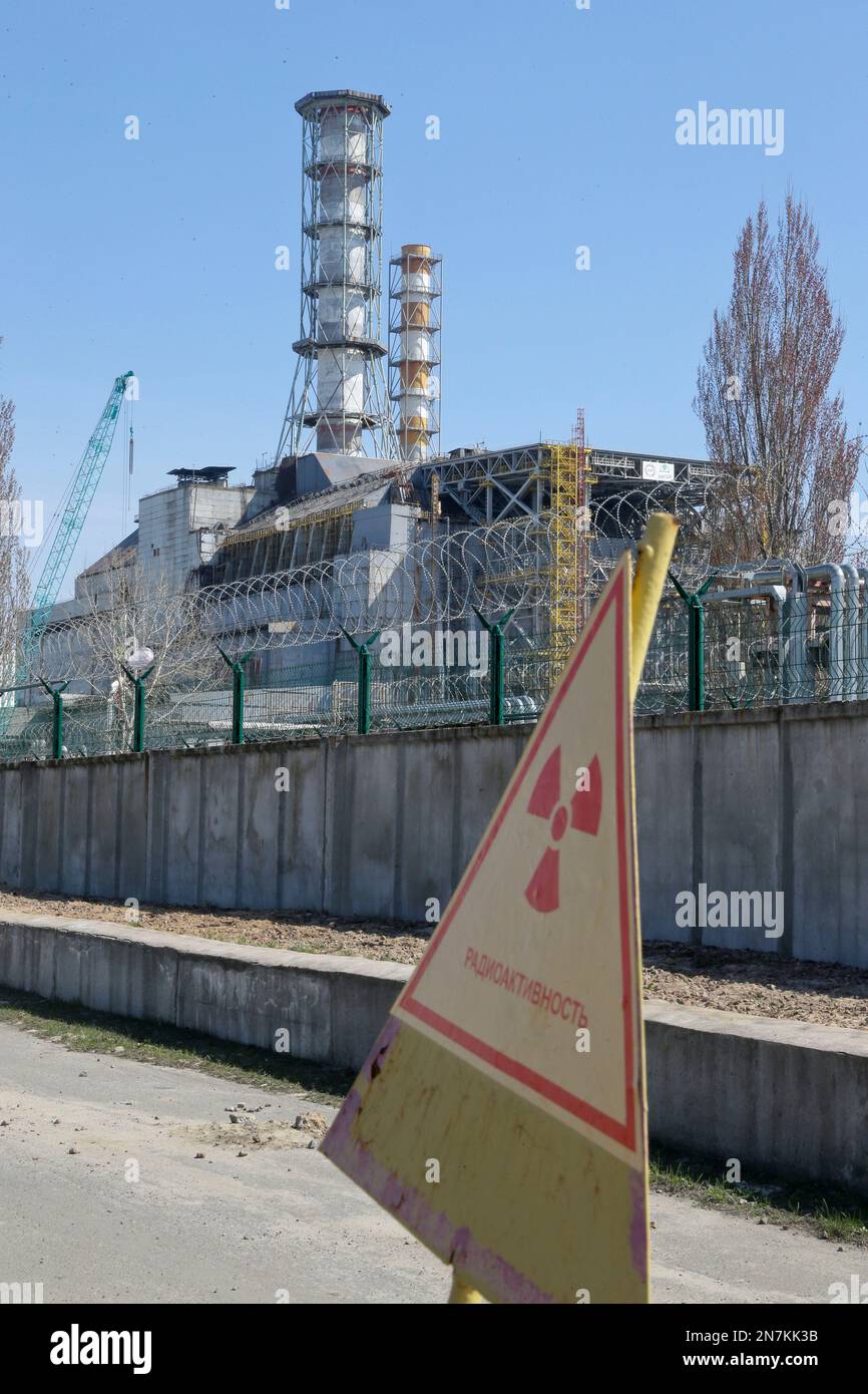 A radioactivity sign is seen in front of a chimney over the damaged ...