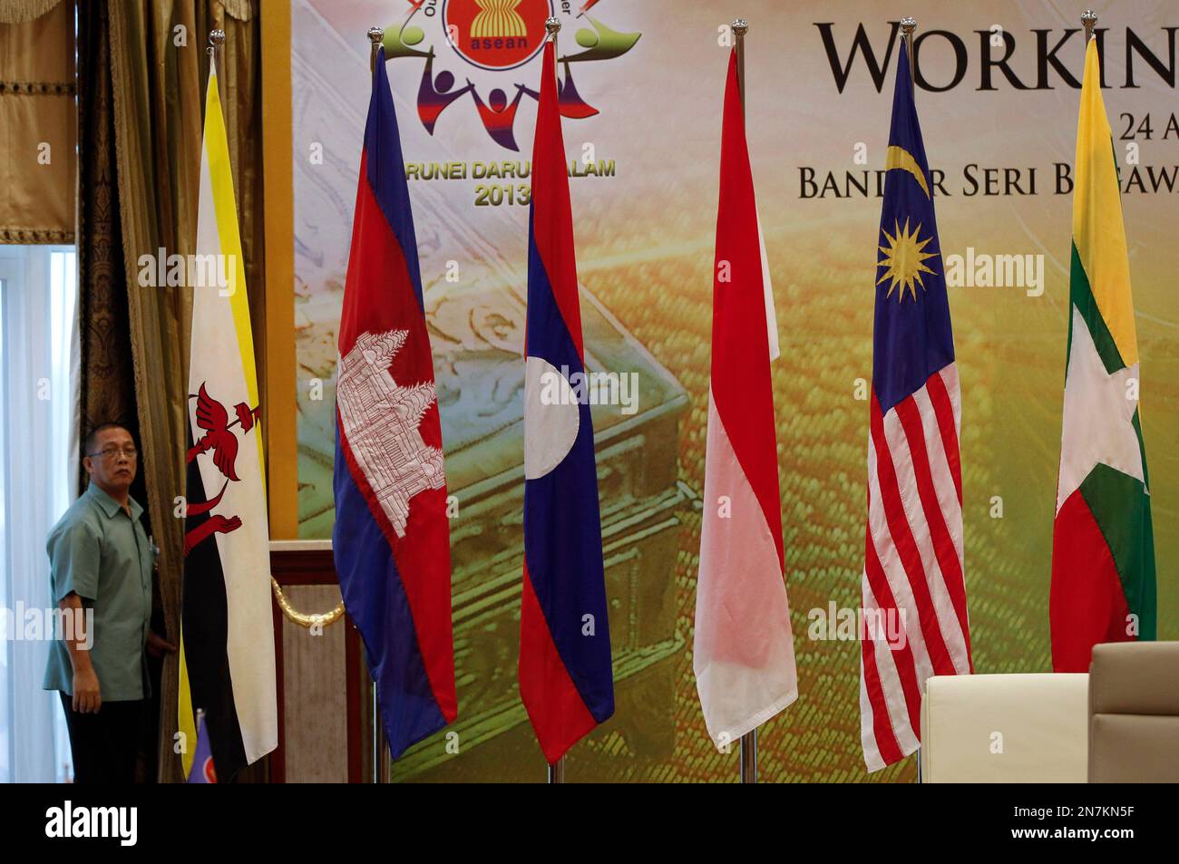 A staff works behind of ASEAN countries' flags at the new prime ...