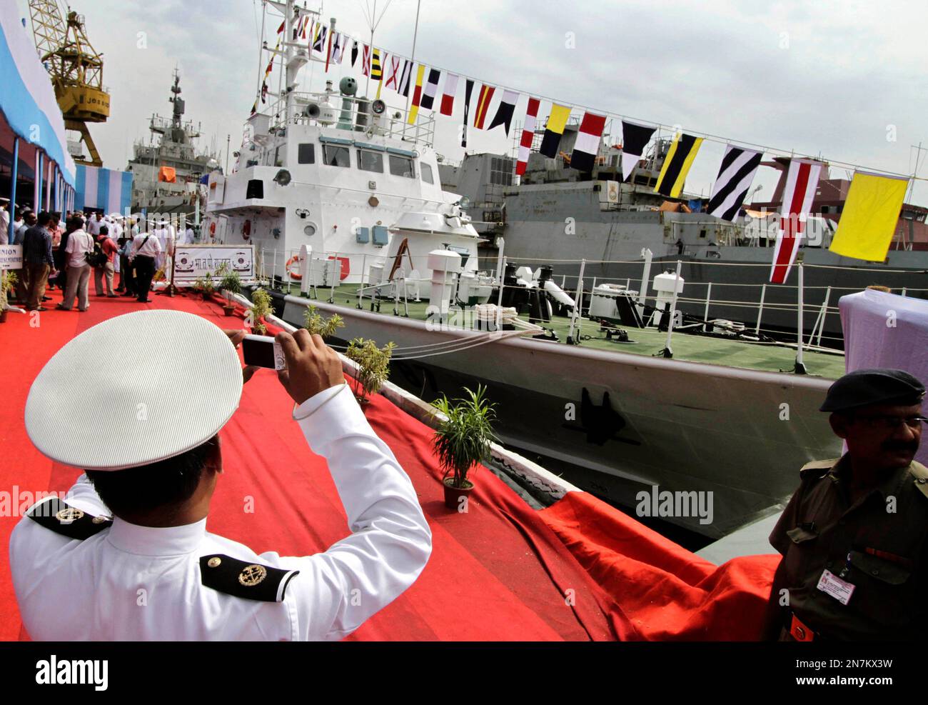 An Indian Coast Guard officer takes a photo of a newly-commissioned ...