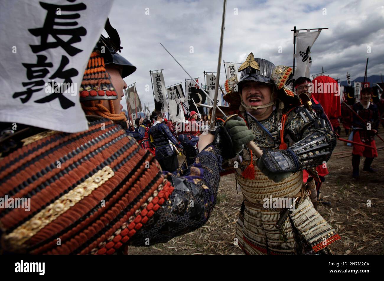 Men in samurai attires engage in a sword fighting to re-enact the ...