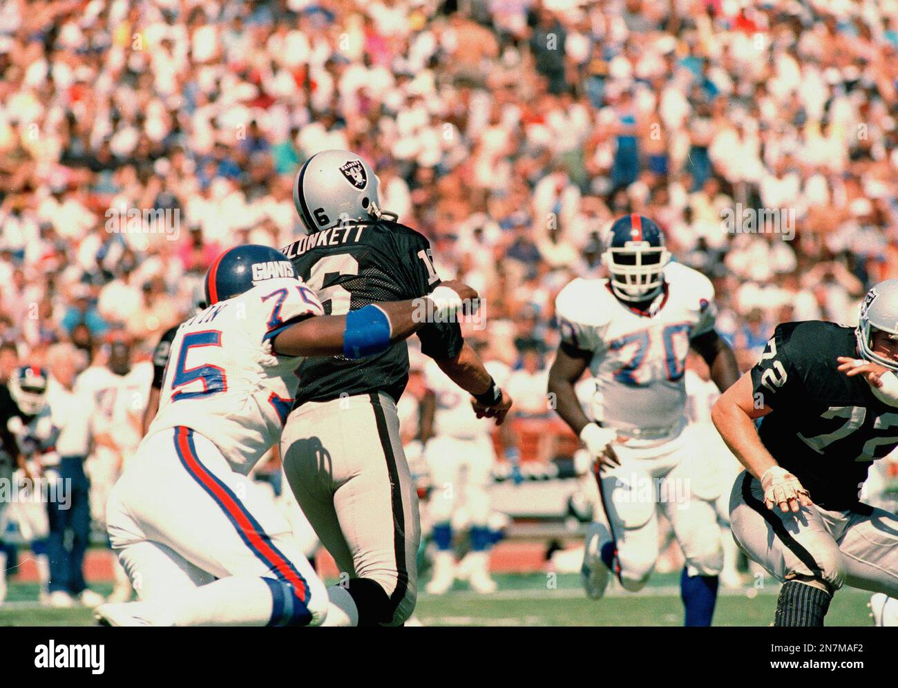 Los Angeles Raiders quarterback Jim Plunkett (16) is dogged by New York ...