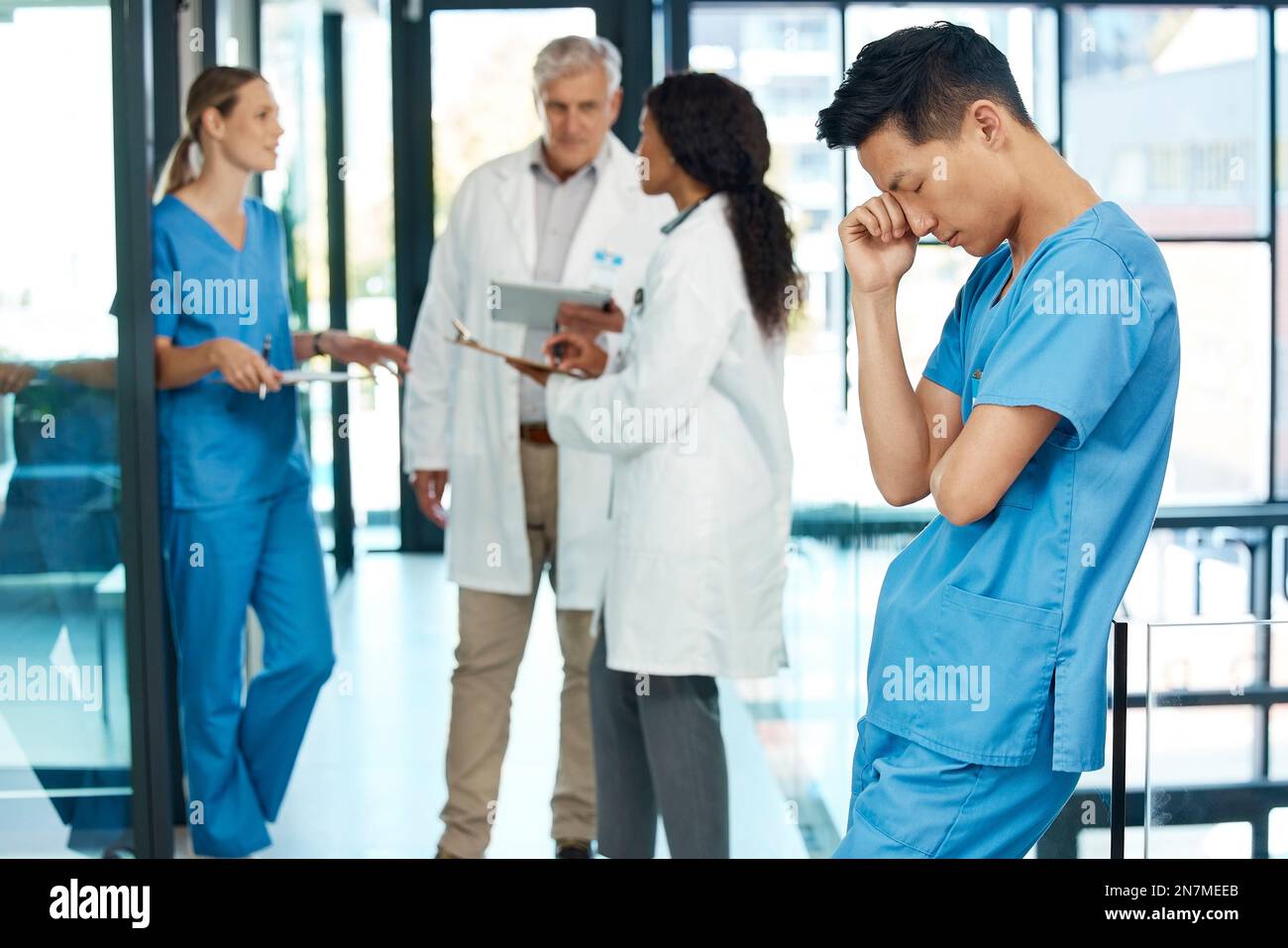 In need of sleep. a young male doctor suffering from a headache at a ...