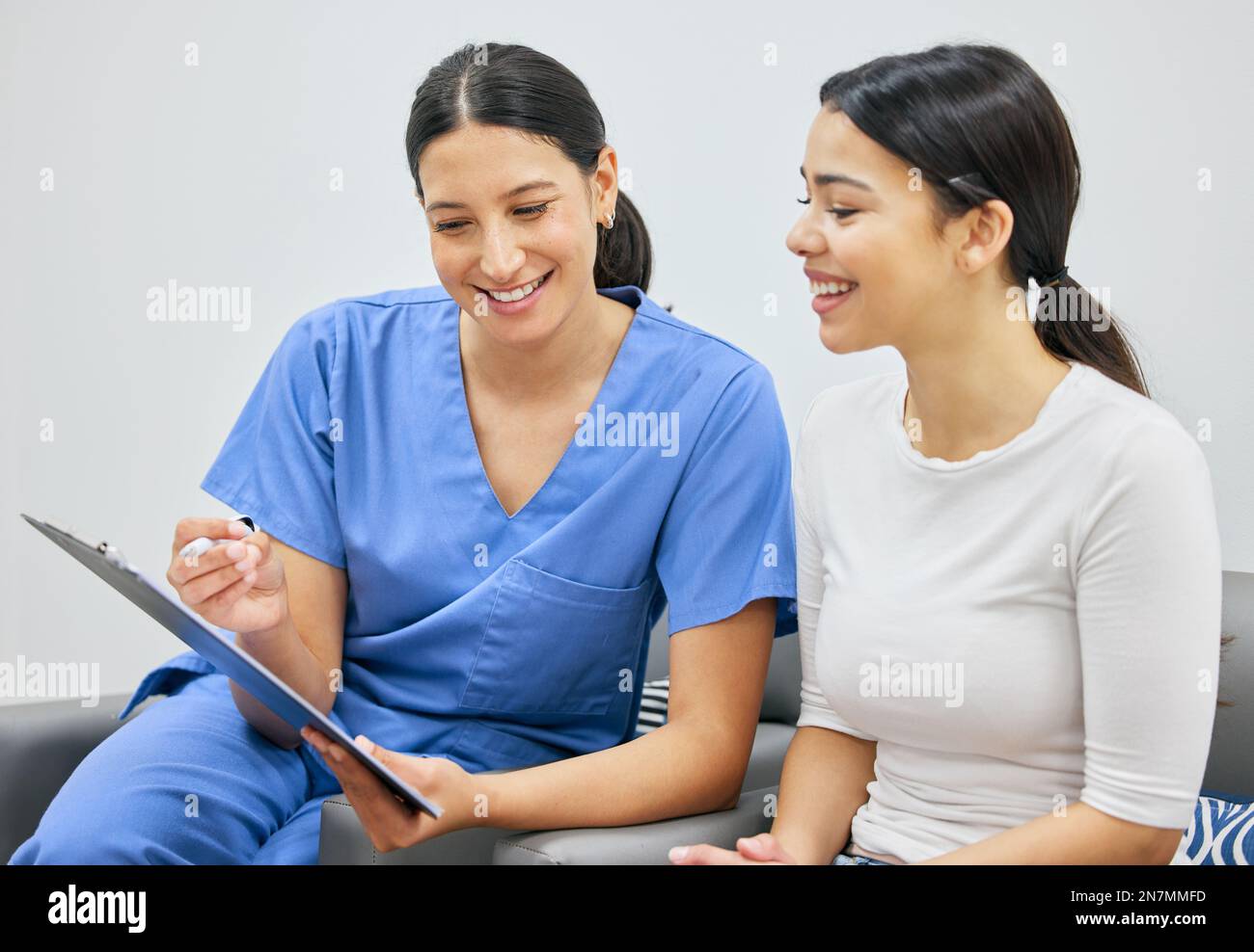Fill this out for us. a young woman filling out a clipboard in her ...