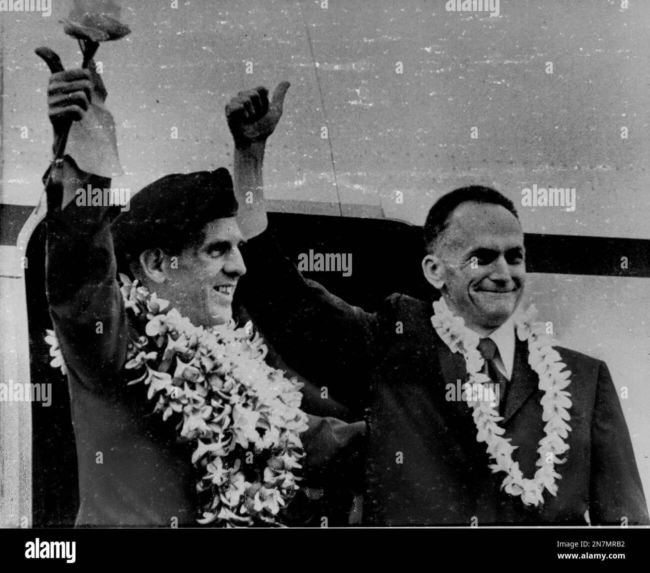 Major Floyd Thompson and Philip Manhard wave from the door of a plane ...