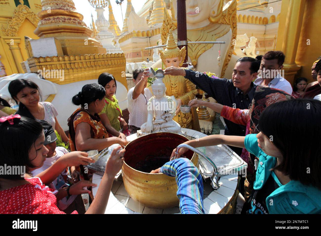Buddhist devotees pour water on a Buddha statue at Myanmar's landmark ...