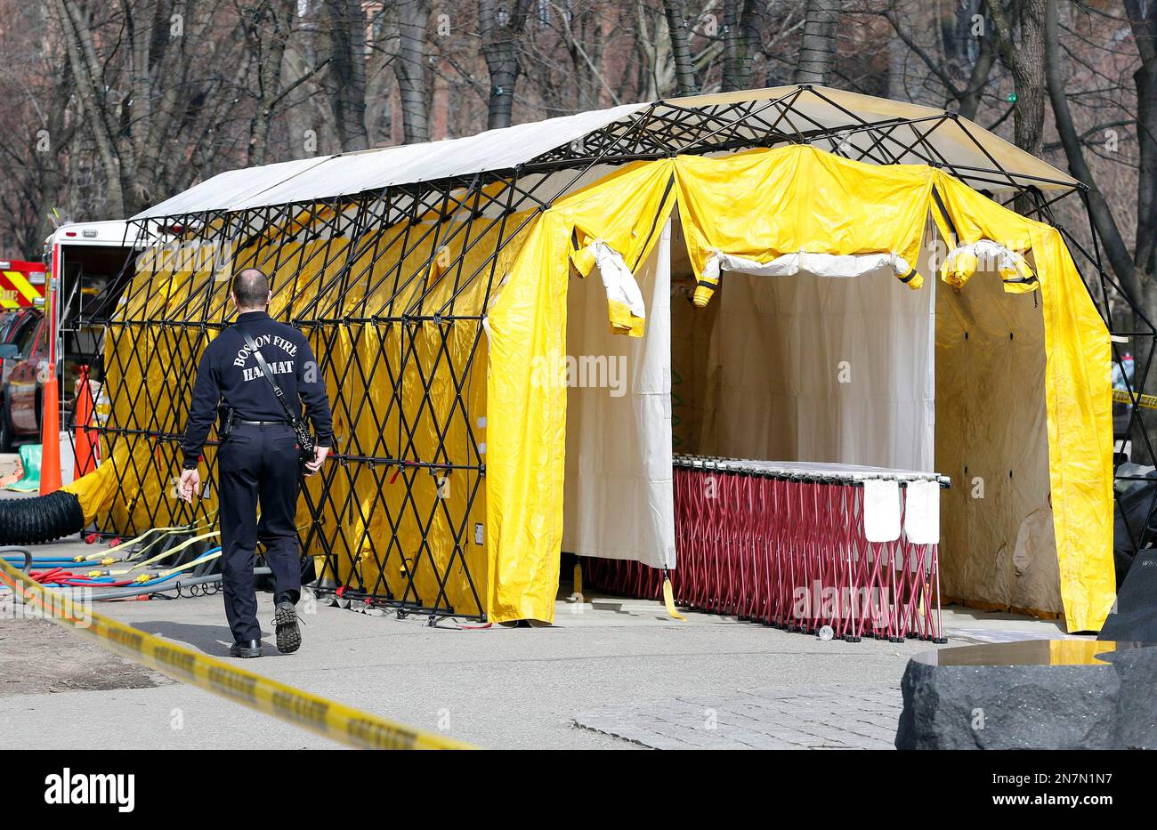 A Boston firefighter walks past a hazmat decontamination unit set up ...